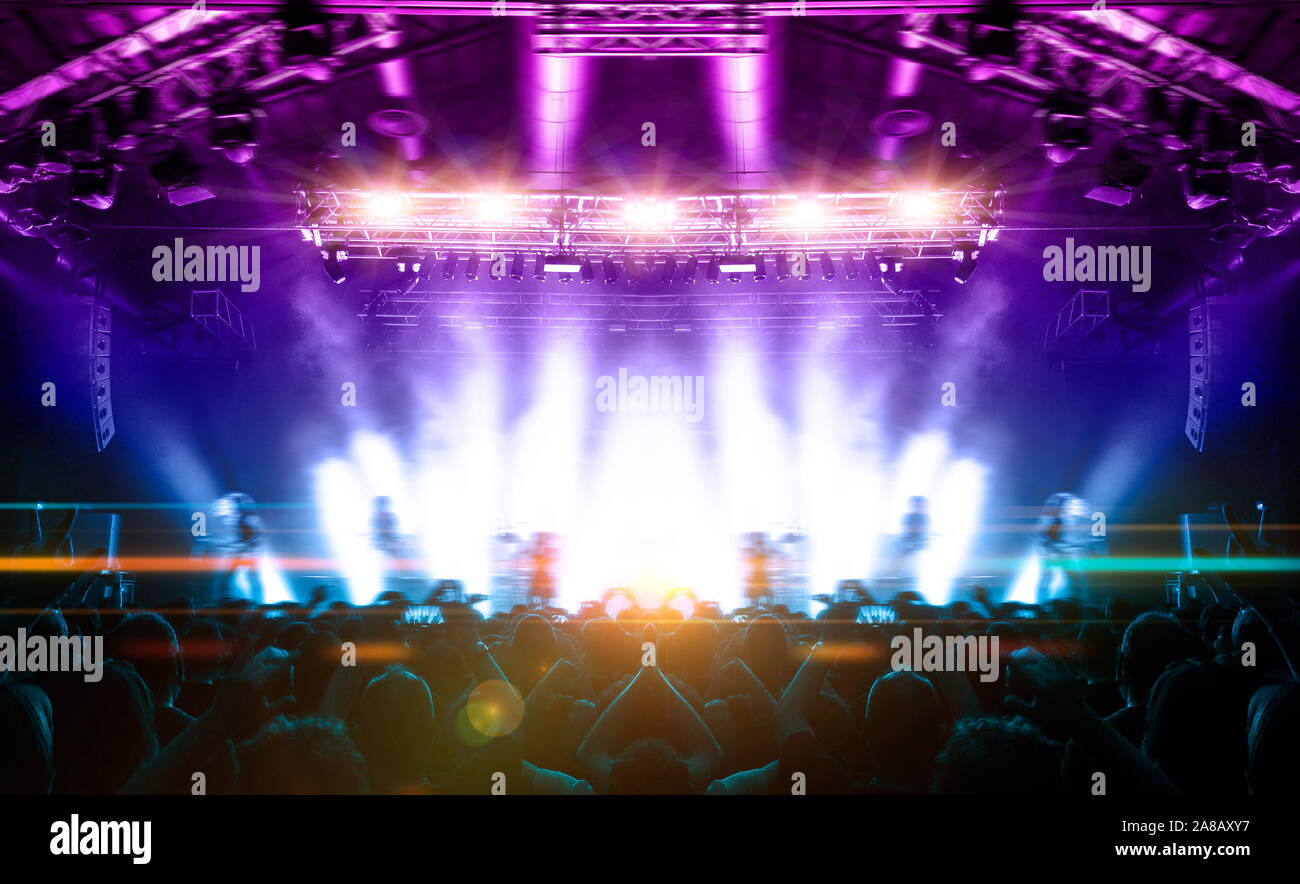 Shot taken inside a concert hall, in the middle of the crowd. The main ...