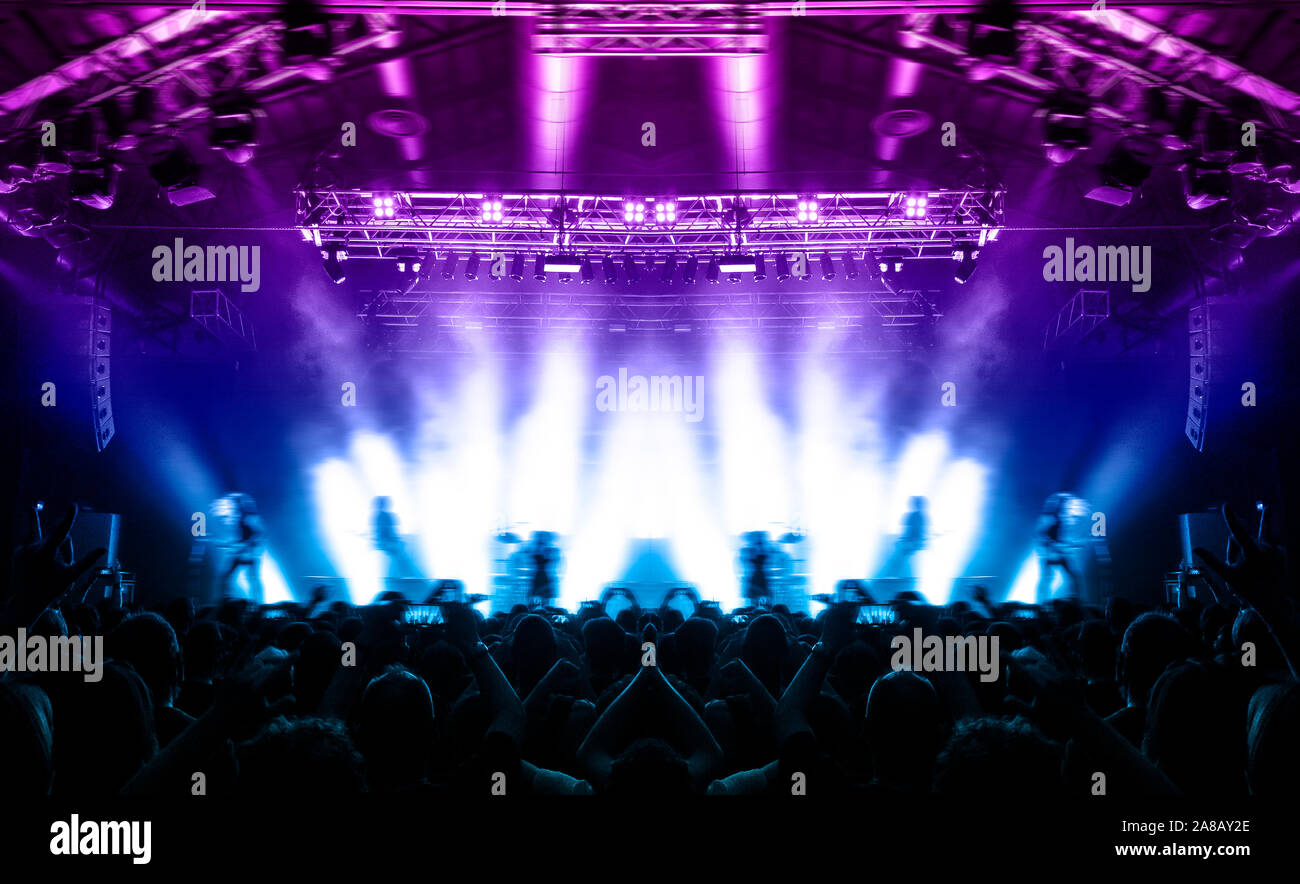 Shot taken inside a concert hall, in the middle of the crowd. The main ...