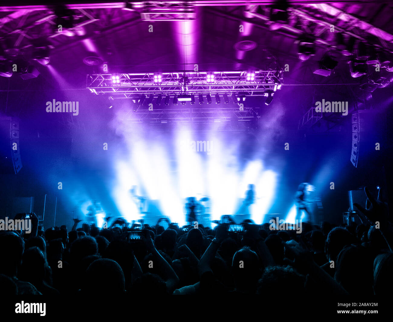 Shot taken inside a concert hall, in the middle of the crowd. The main ...
