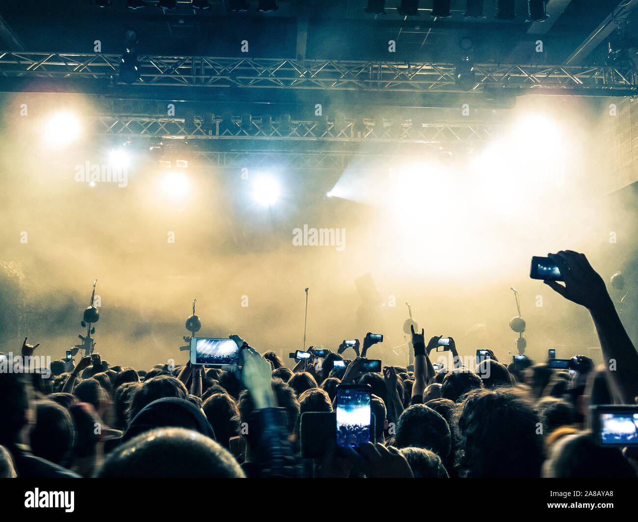 Shot taken inside a concert hall, in the middle of the crowd. The main ...
