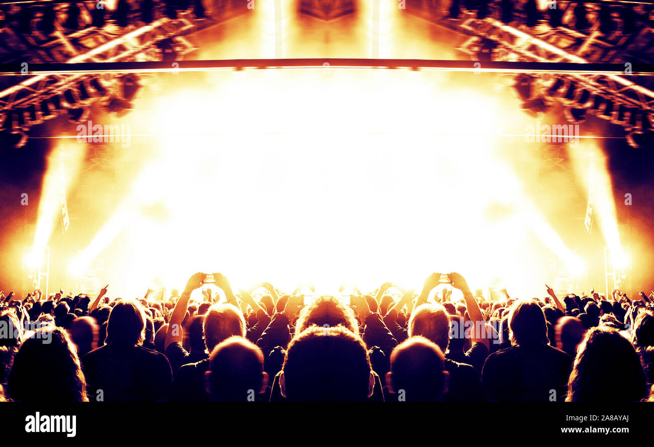 Shot taken inside a concert hall, in the middle of the crowd. The main ...