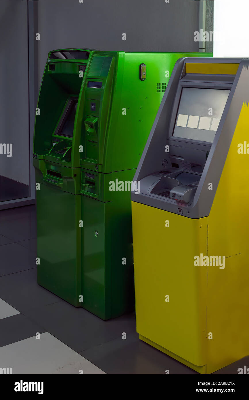 ATM machine. Two yellow and green ATMs in the lobby of the shopping ...