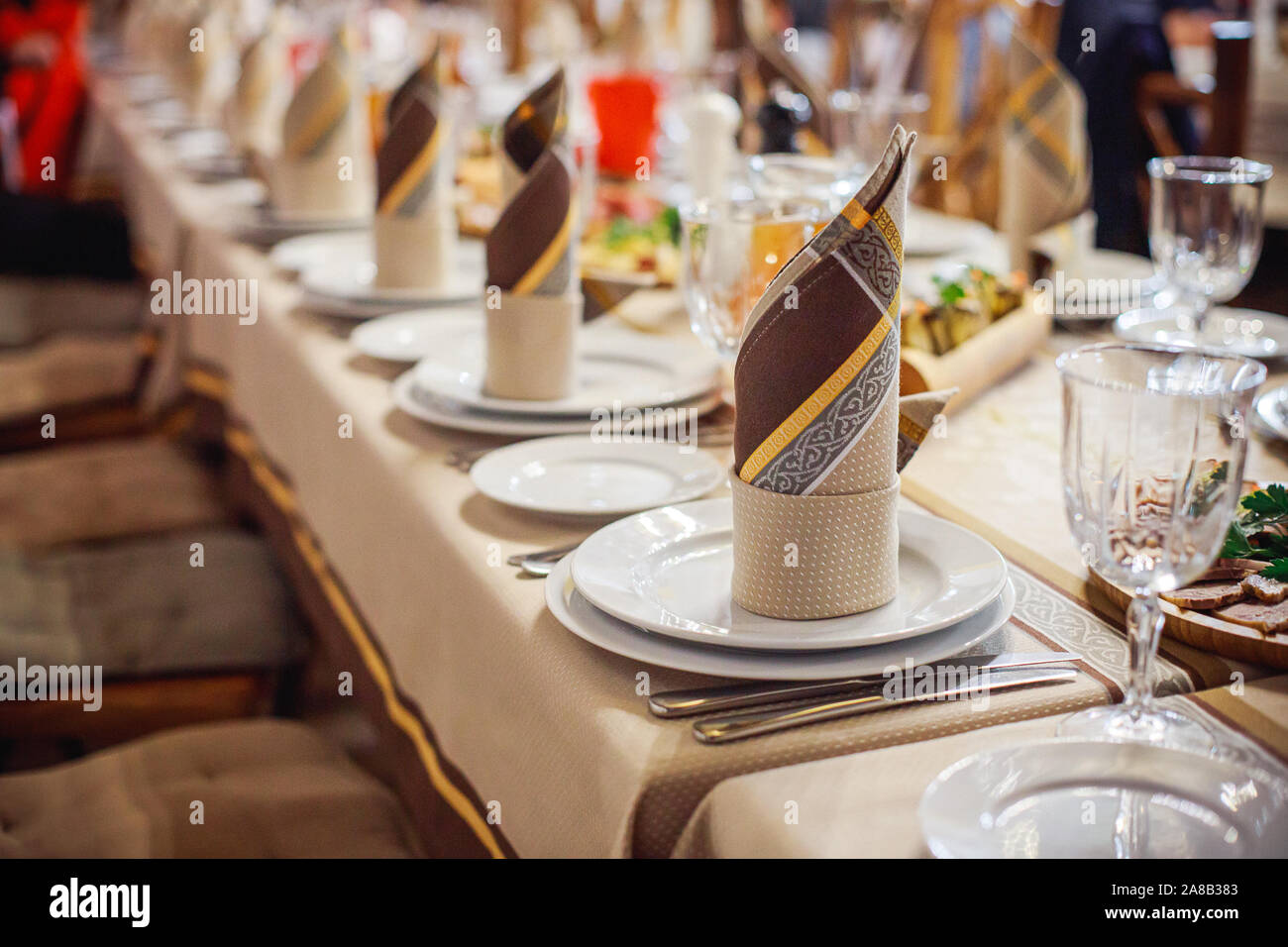 Beautifully folded napkins on served table. Brown napkins on white ...