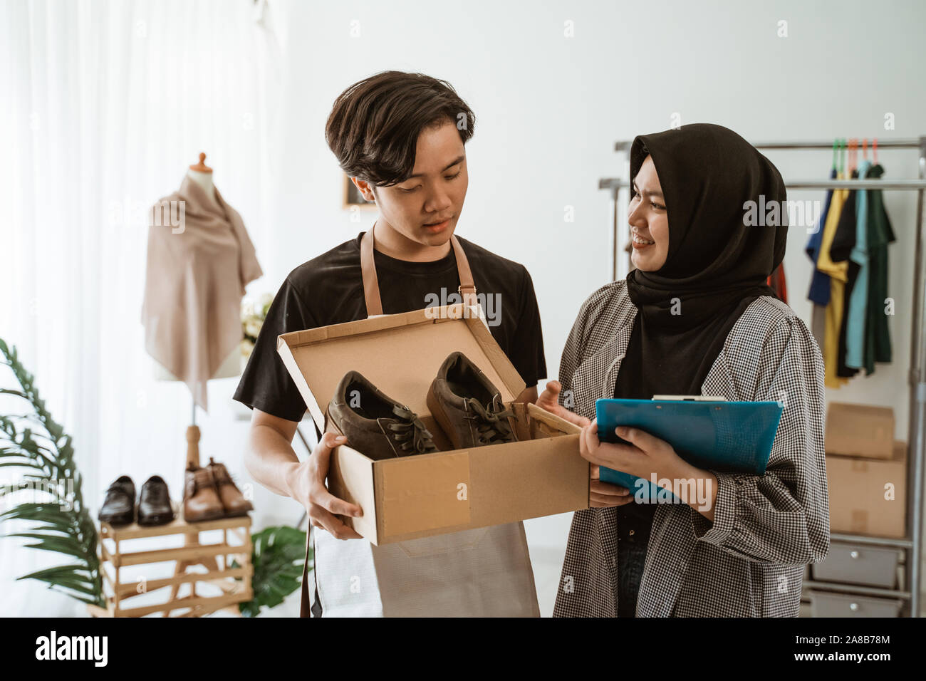 small business owner looking at their product getting ready to send to ...