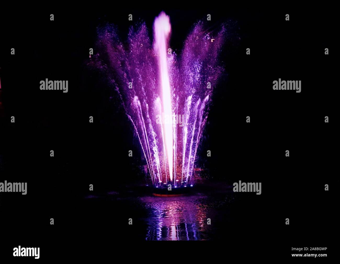 Night light purple fountain splash with reflection on water. Rusanivka ...