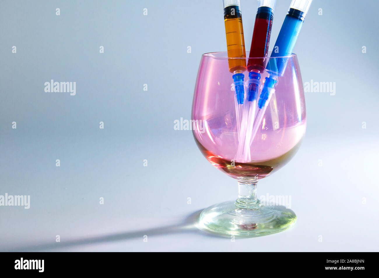 Set of medical syringes in a glass with colored injections for ...