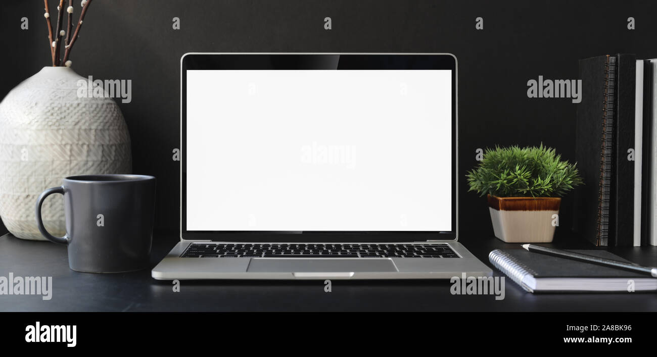 Open blank screen laptop computer in dark modern office room with ...