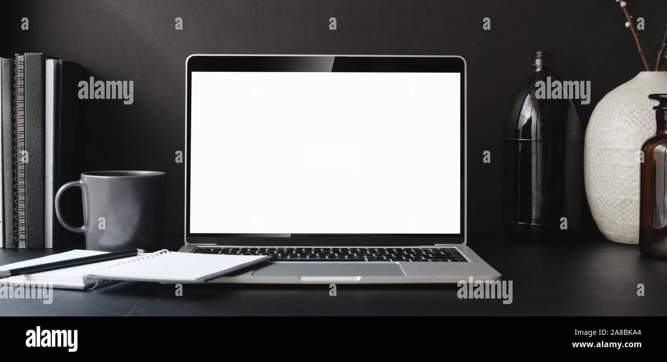 Open blank screen laptop computer in dark modern office room with ...