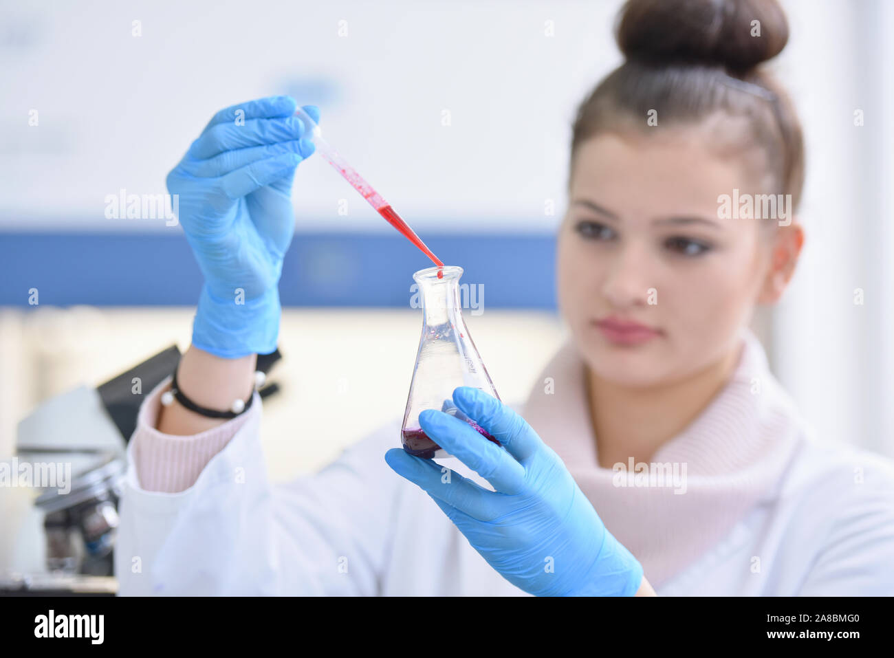 Young female Laboratory scientist working at lab with test tubes and ...