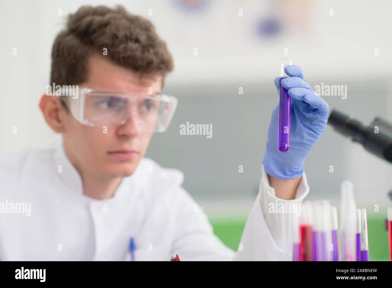 Young male Laboratory scientist working at lab with test tubes and ...