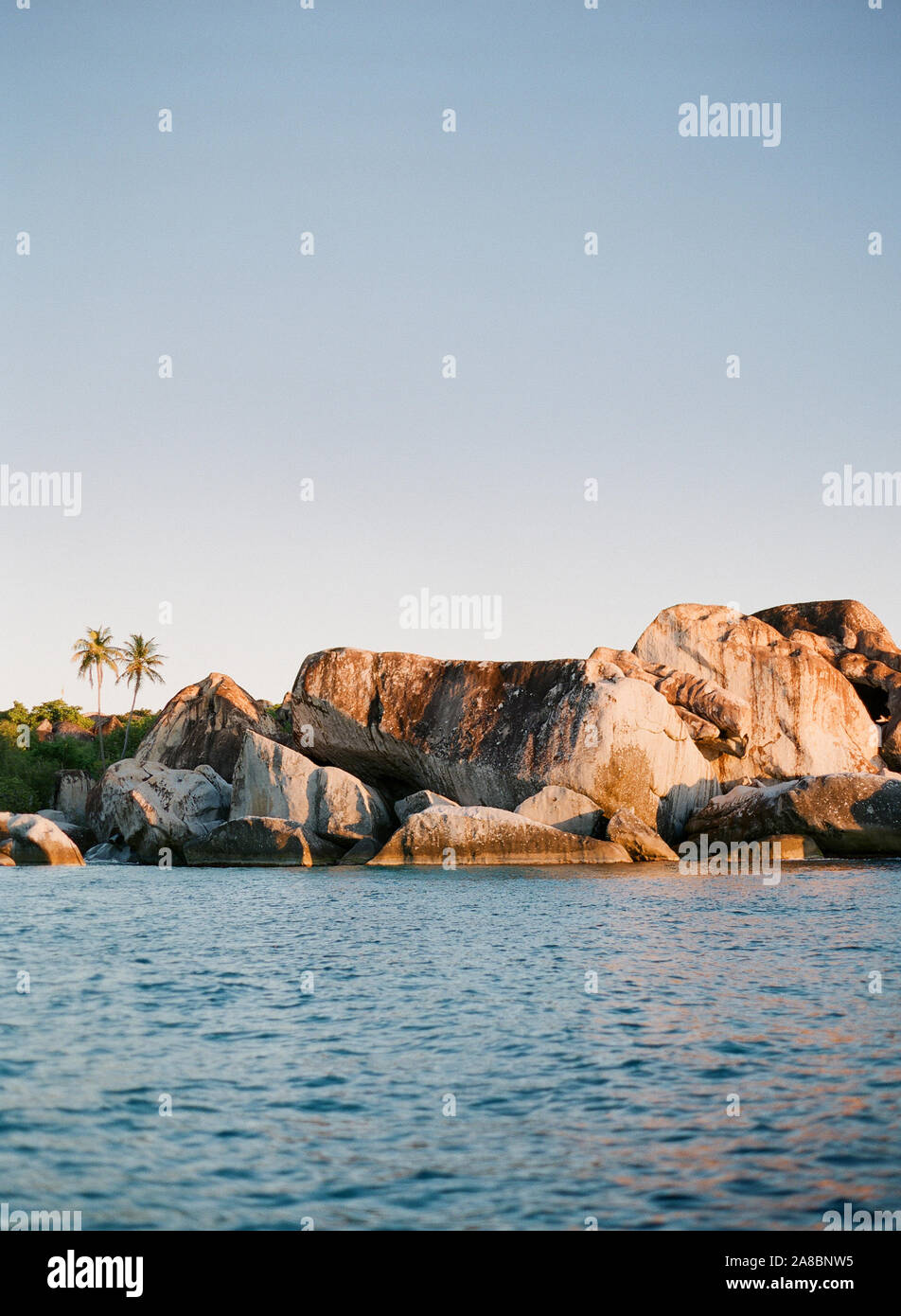 Landscape at sunset on the rock boulders at The Baths beach with palm ...