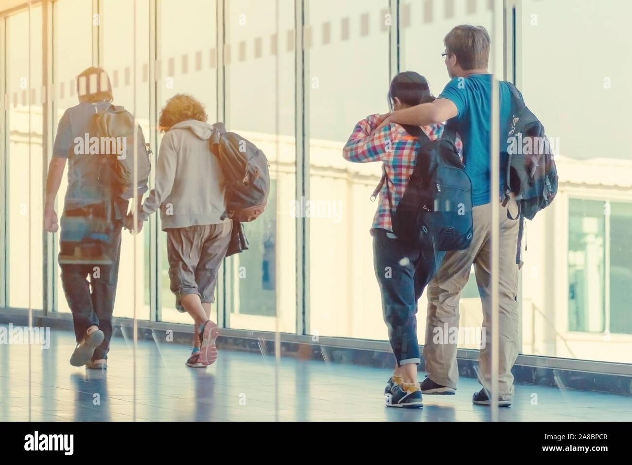Back view of passengers and traveling luggage walking the airplane ...