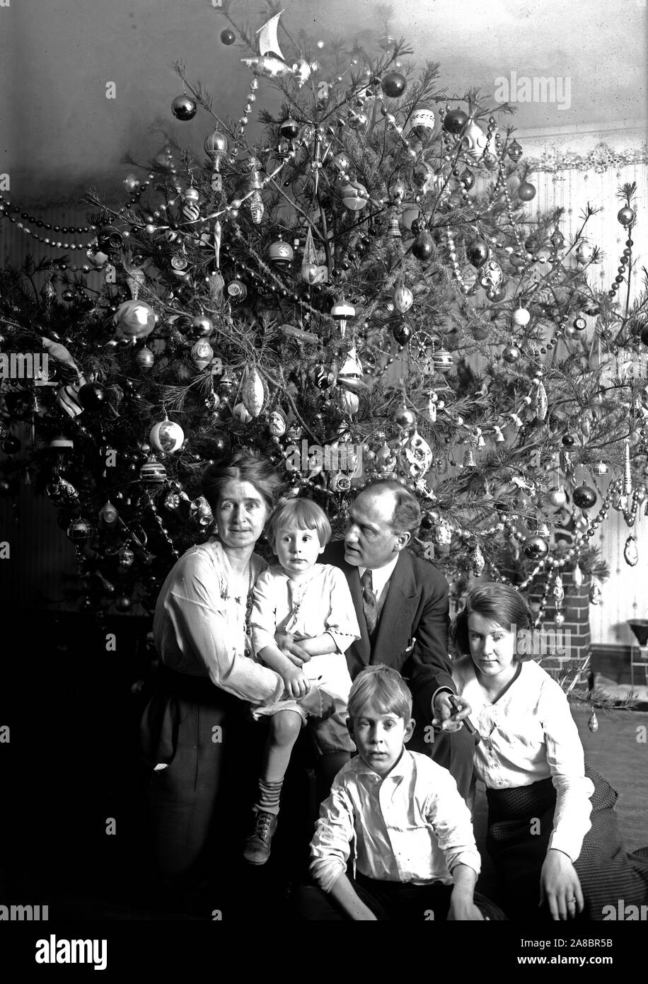 Family in front of their Christmas tree at home in early 1900s ca. 1921 ...