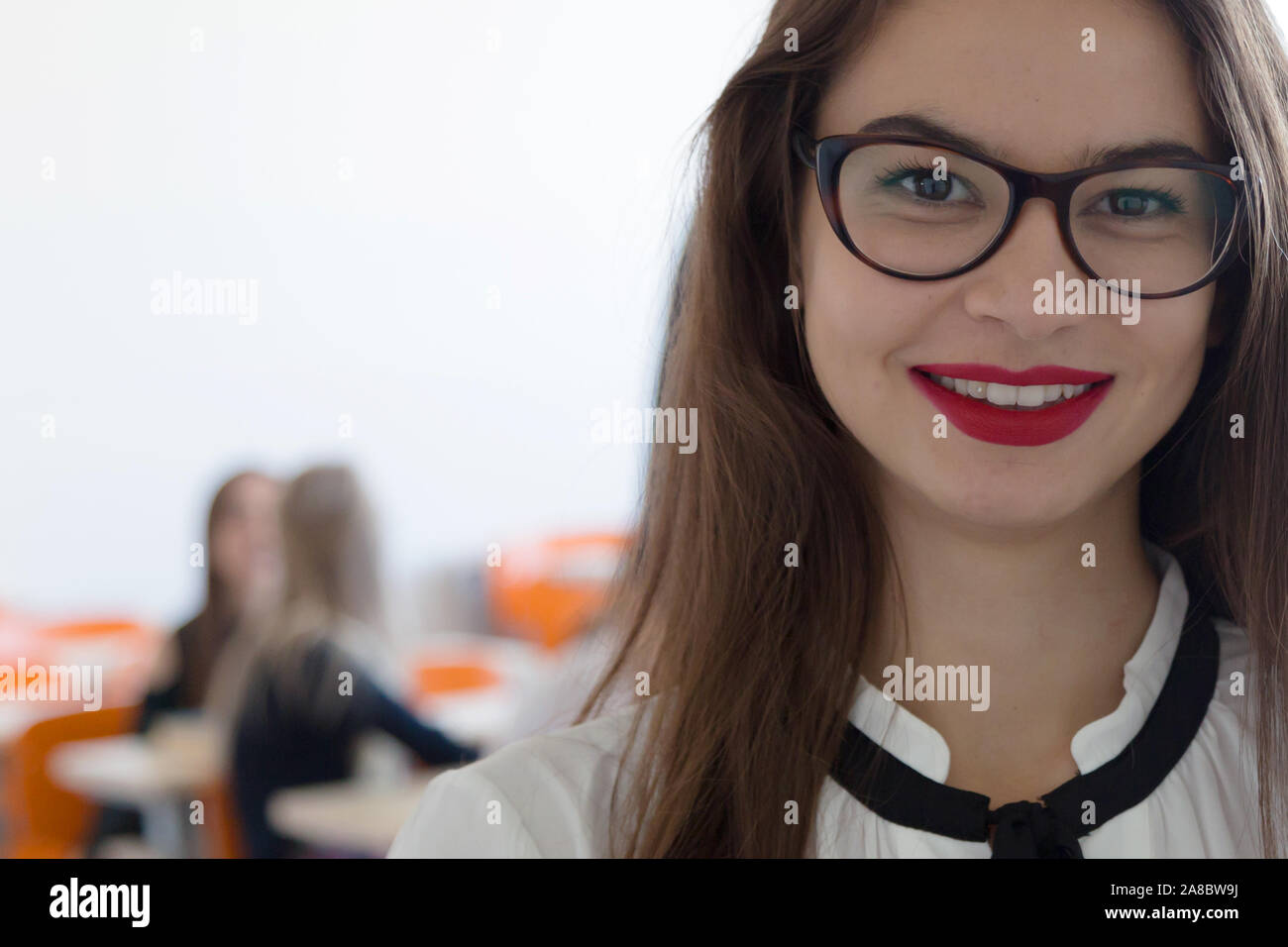 Beautiful female student wearing glasses standing at university campus ...