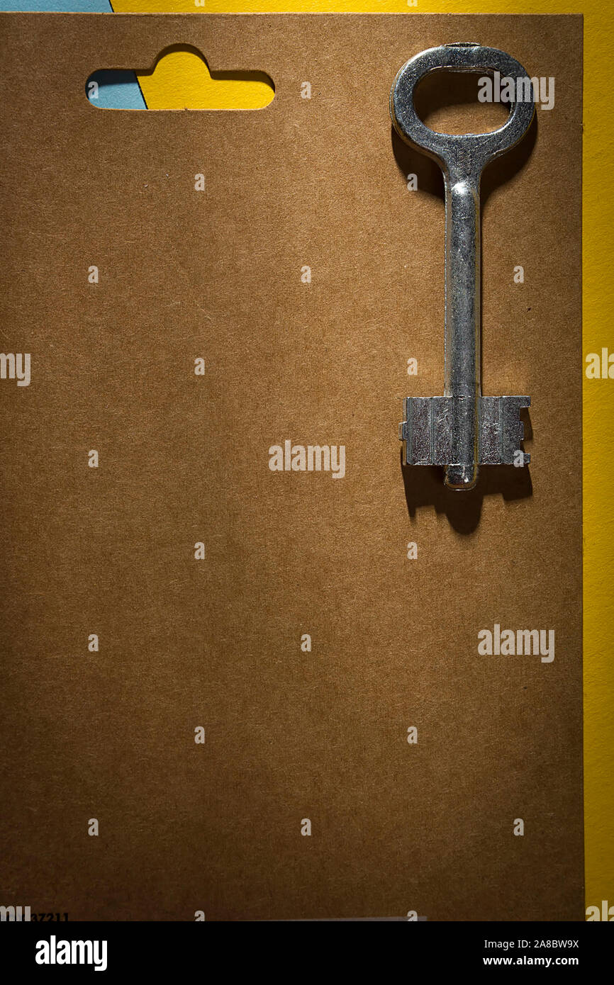Metal old key on a brown cardboard tablet Stock Photo - Alamy