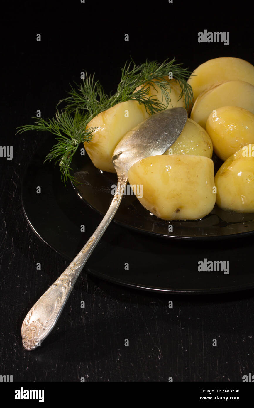 Welded potatoes on a black plate on a dark background Stock Photo - Alamy