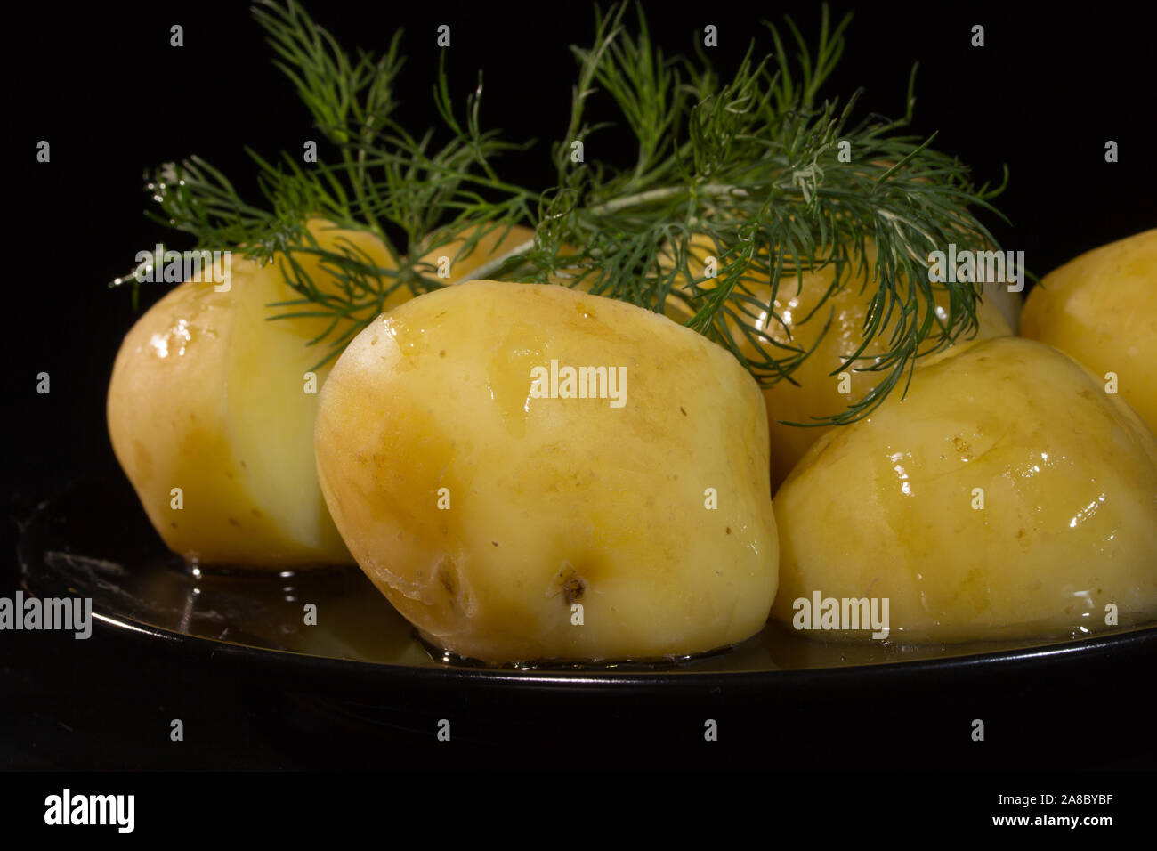 Welded potatoes on a black plate on a dark background Stock Photo - Alamy
