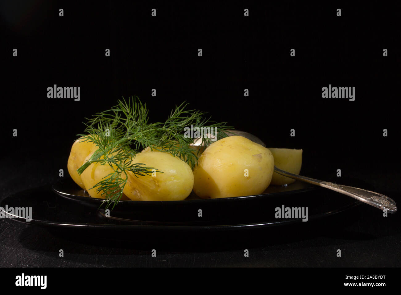 Welded potatoes on a black plate on a dark background Stock Photo - Alamy