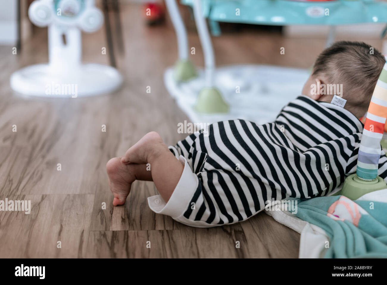 Adorable baby boy learning to crawl on the floor at home. Side view ...