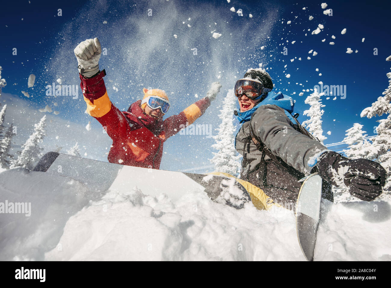 Happy couple of snowboarders are having fun in forest. Ski resort ...