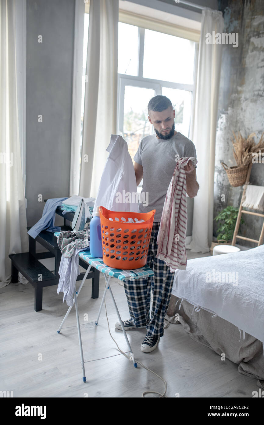 Bearded man preparing clothes for laundry at the weekend Stock Photo ...