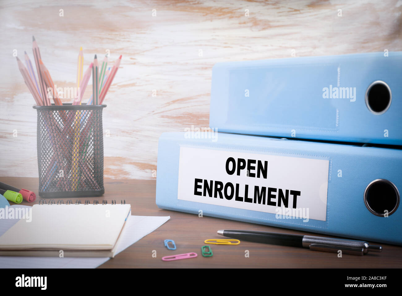 Open Enrollment. Office Binder on Wooden Desk. On the table colored ...