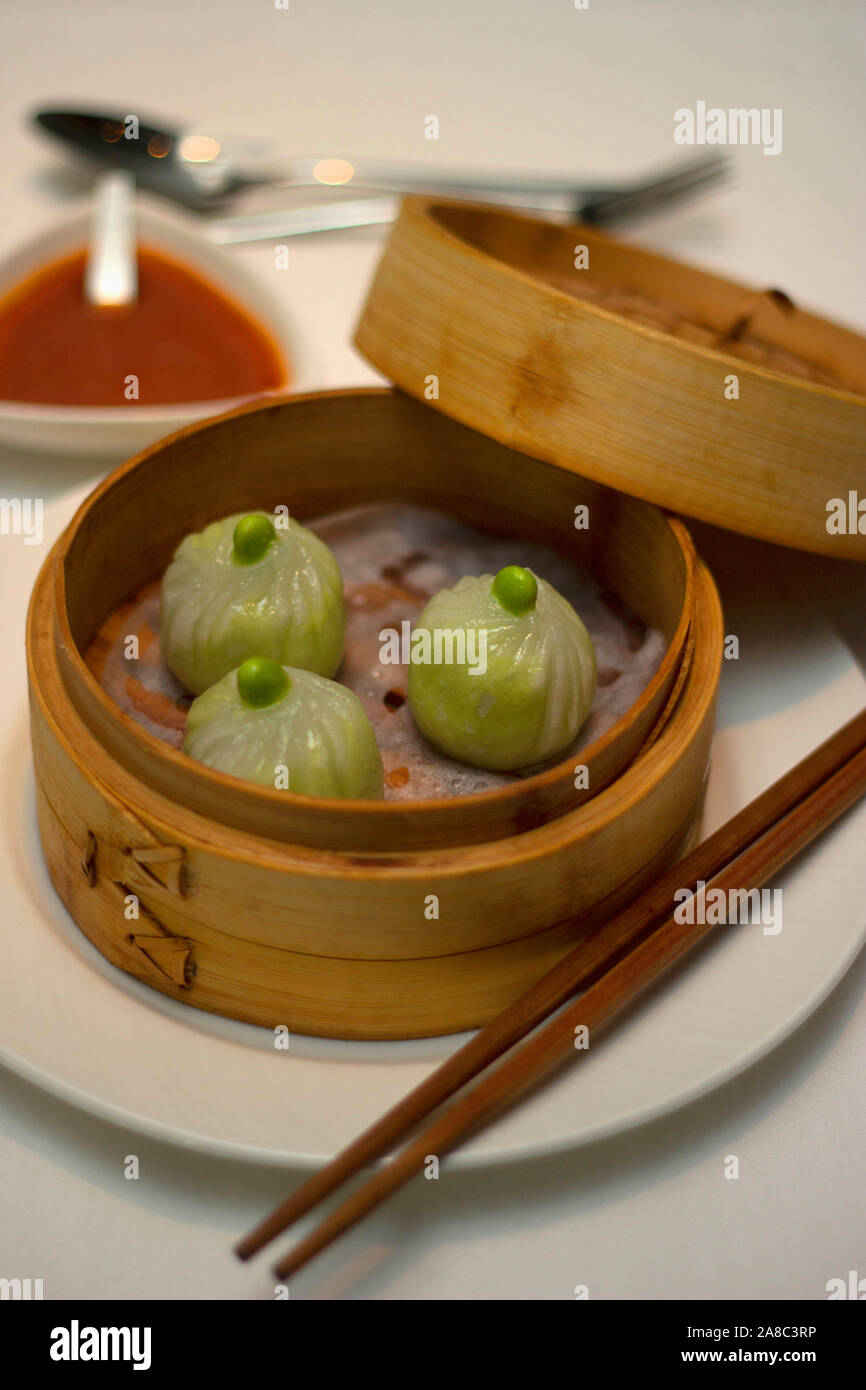 Dim sum of green peas in wooden basket with chopsticks Stock Photo - Alamy