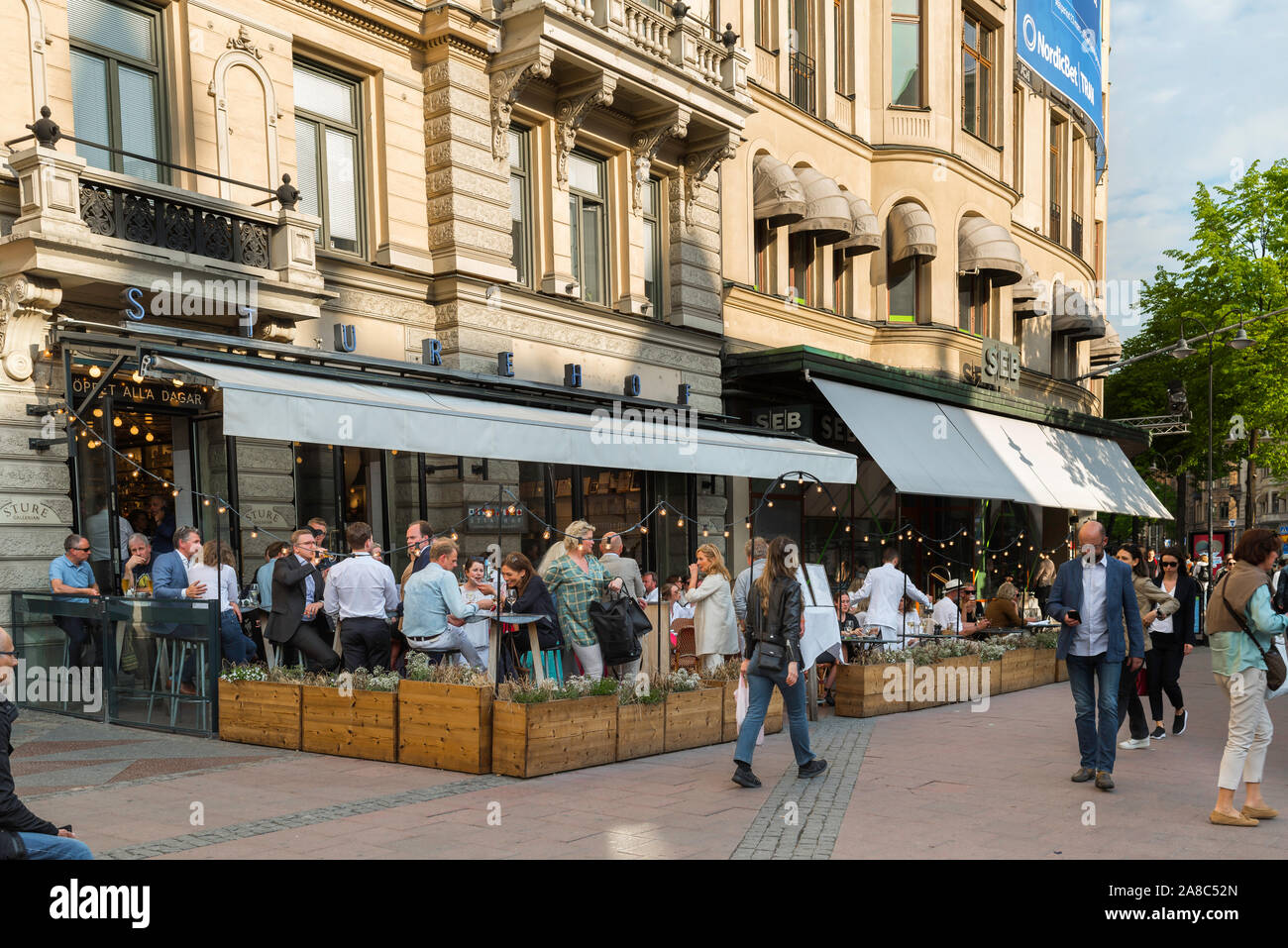 Stockholm cafe bar, view in summer of Swedish people relaxing at tables ...