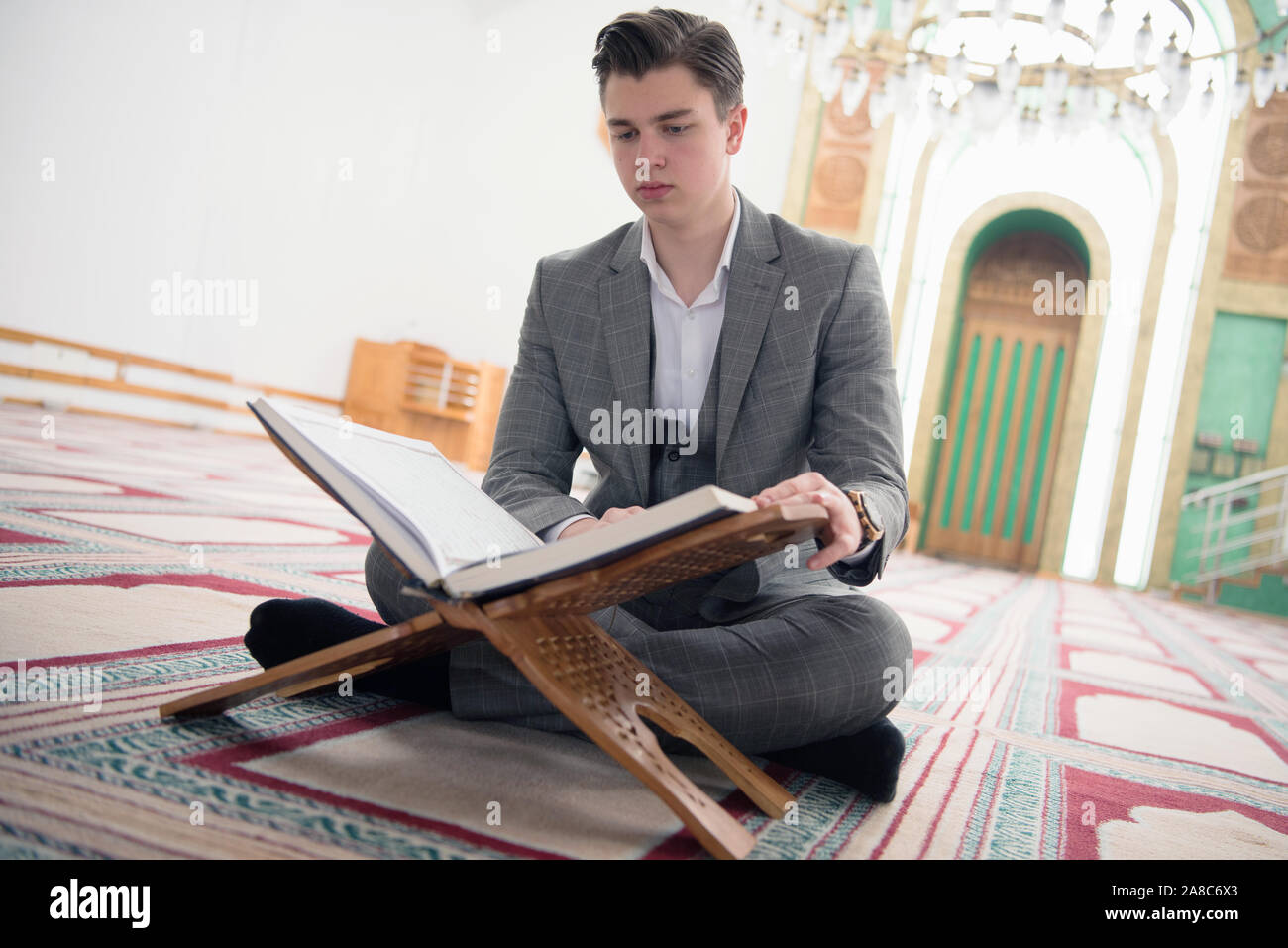 Religious young hafiz muslim man praying inside the mosque and reading ...