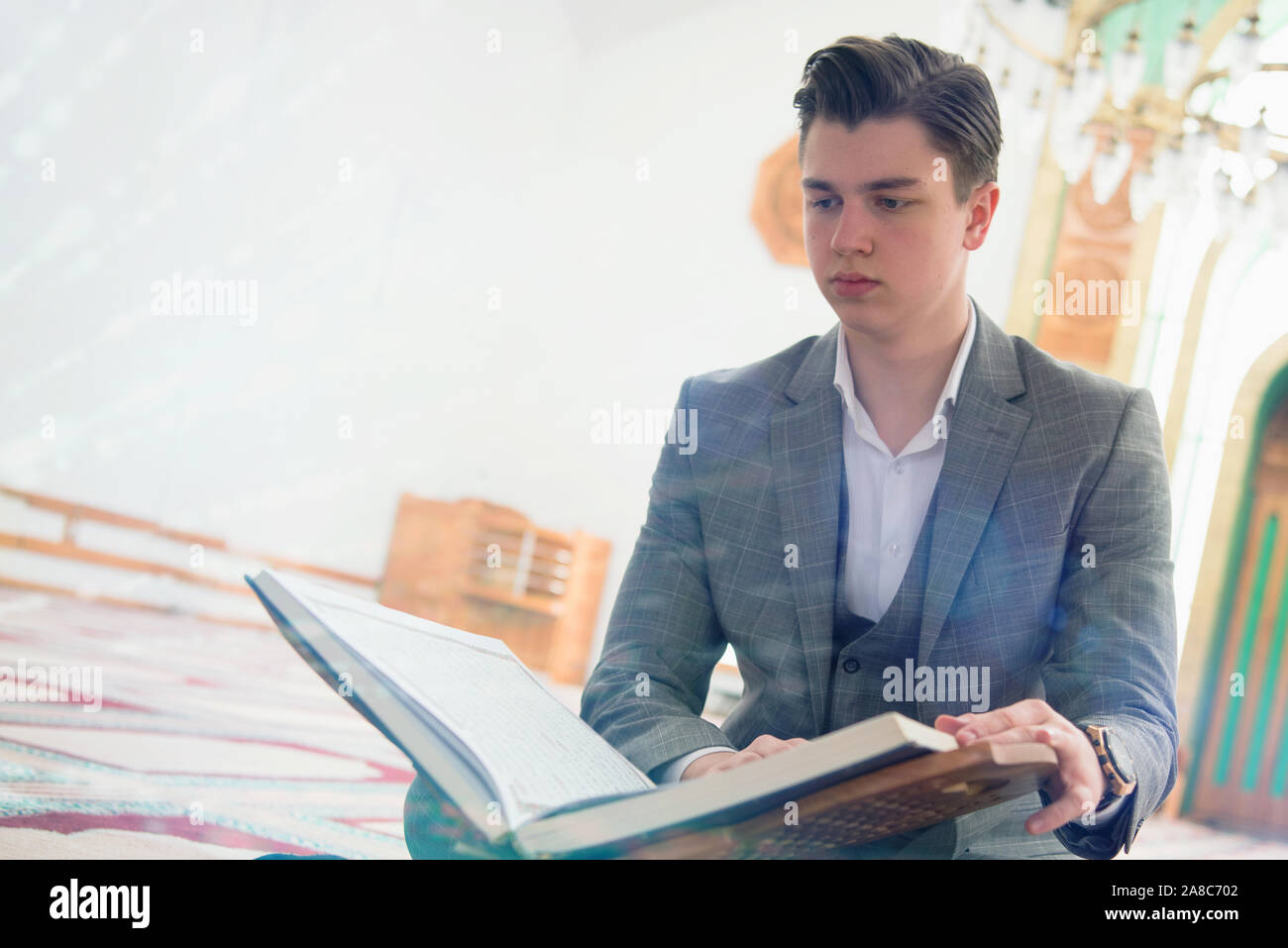 Religious muslim man praying inside the mosque and reading holy book ...
