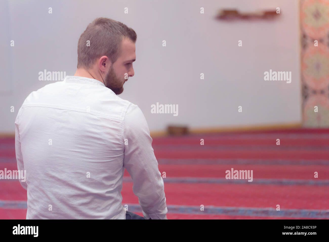 Young religious european muslim man praying inside the beautiful big ...