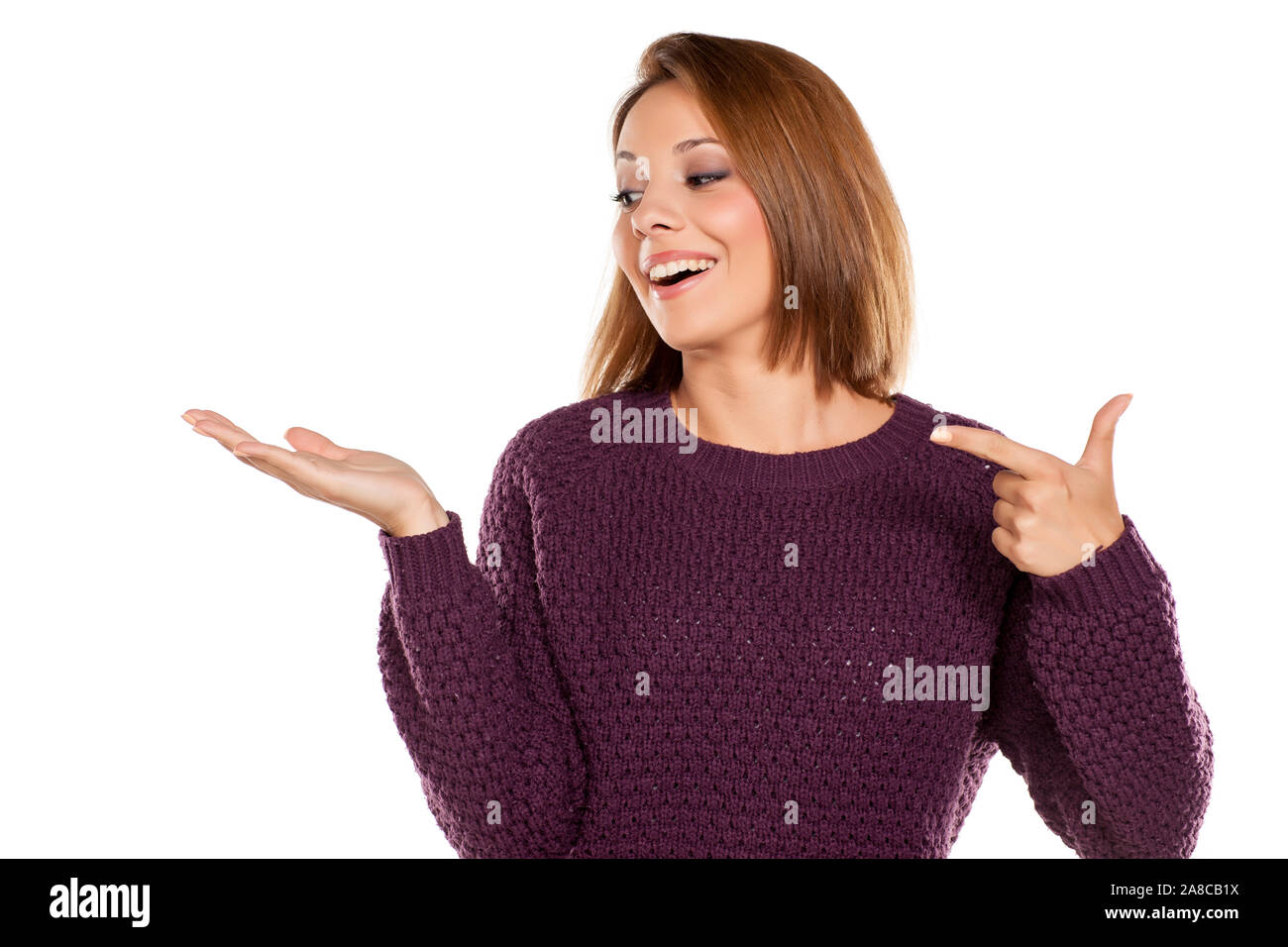young beautiful woman in a purple sweater and jeans, holding imaginary ...