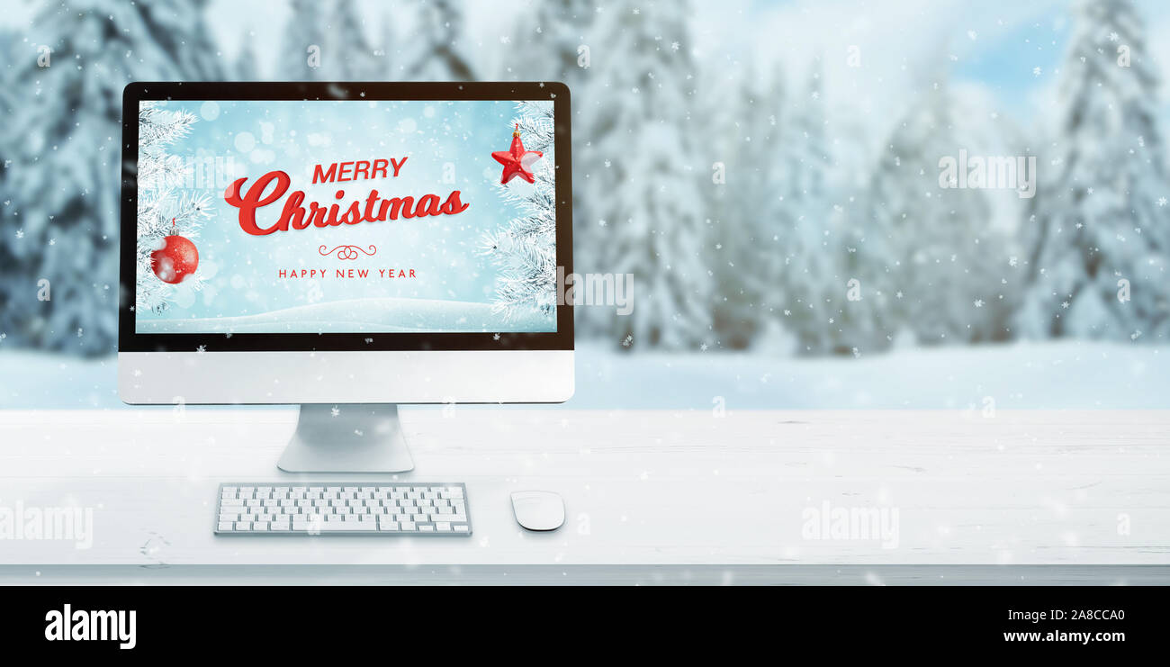 Merry Christmas greeting on computer display on white wooden desk. Copy ...