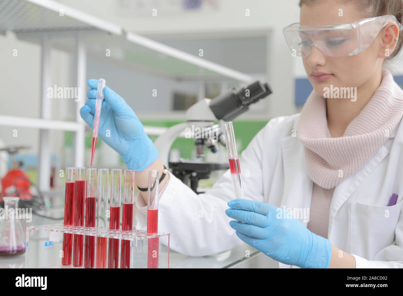 Young female Laboratory scientist working at lab with test tubes and ...