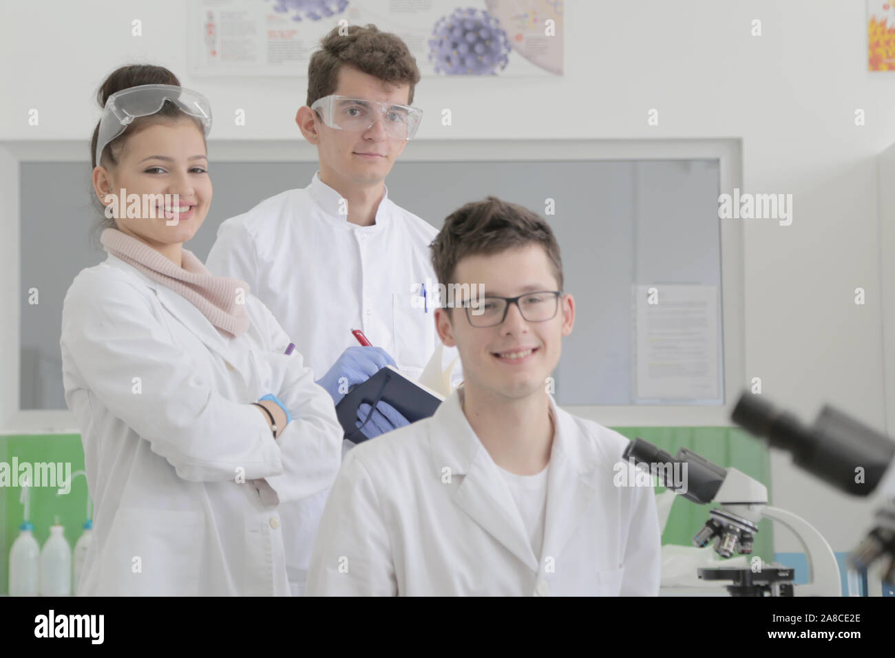 Group of young Laboratory scientists working at lab with test tubes and ...