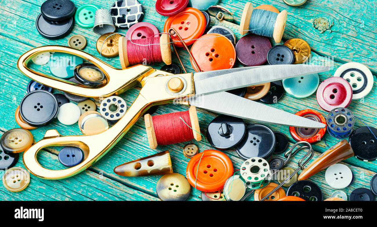 Sewing tools, scissors, buttons and threads on wooden table Stock Photo ...