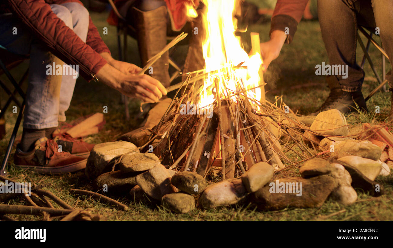 Handheld footage of man making camp fire for his friends in a cold ...