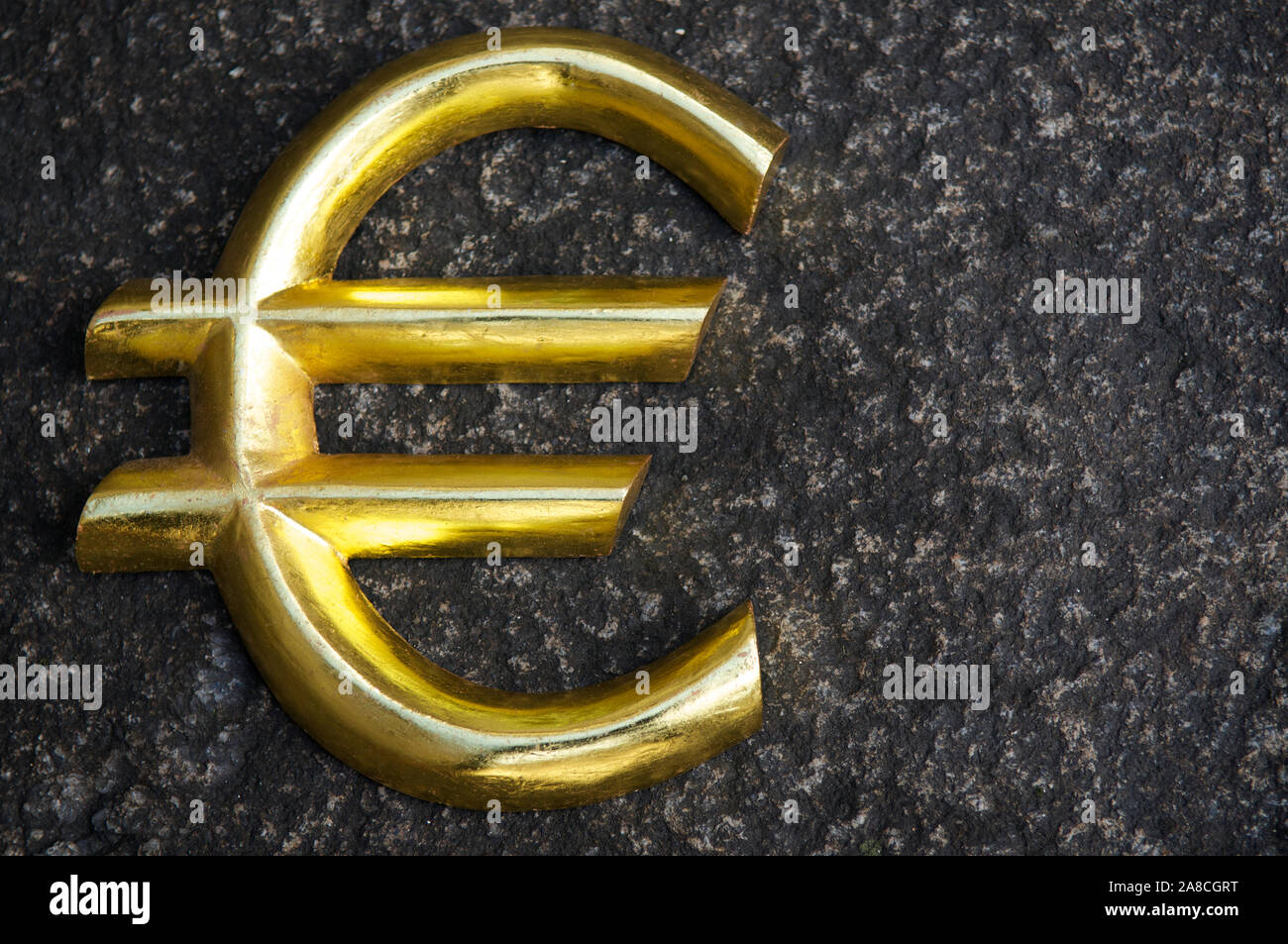Golden euro currency symbol siting outdoors on gritty stone background ...