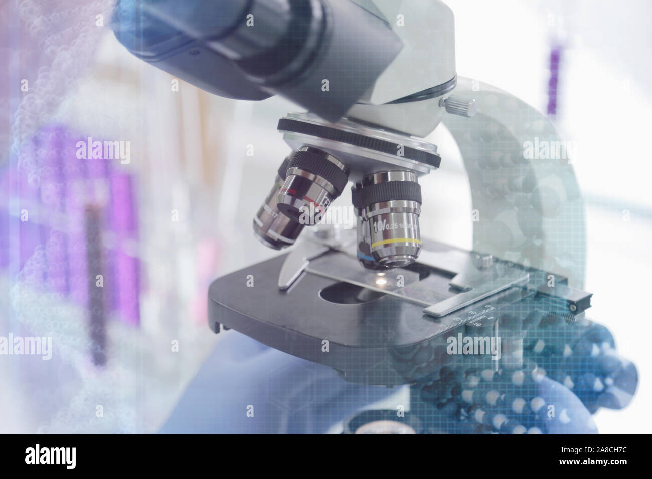 Young male male scientist looking through a microscope in a laboratory ...