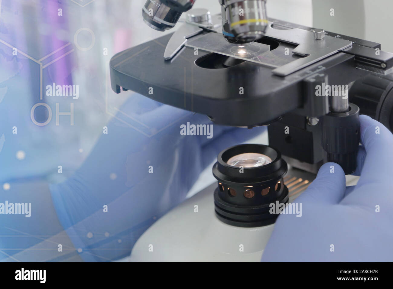 Young male male scientist looking through a microscope in a laboratory ...