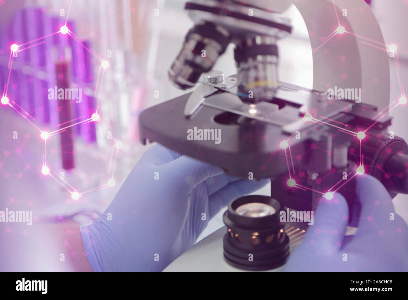 Young male male scientist looking through a microscope in a laboratory ...