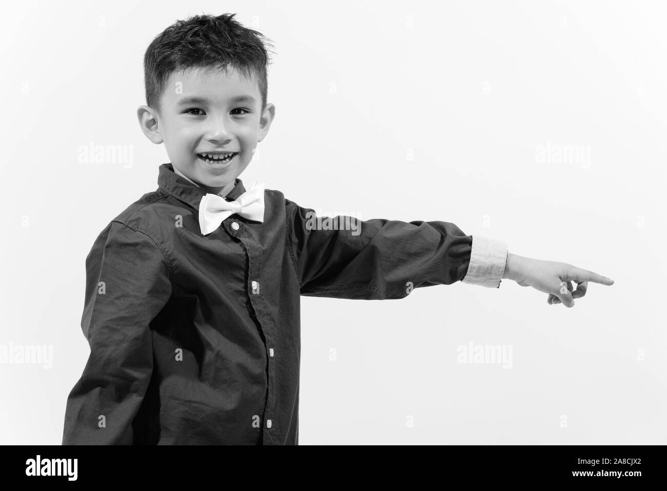 Studio shot of cute happy boy smiling and pointing finger at side Stock ...