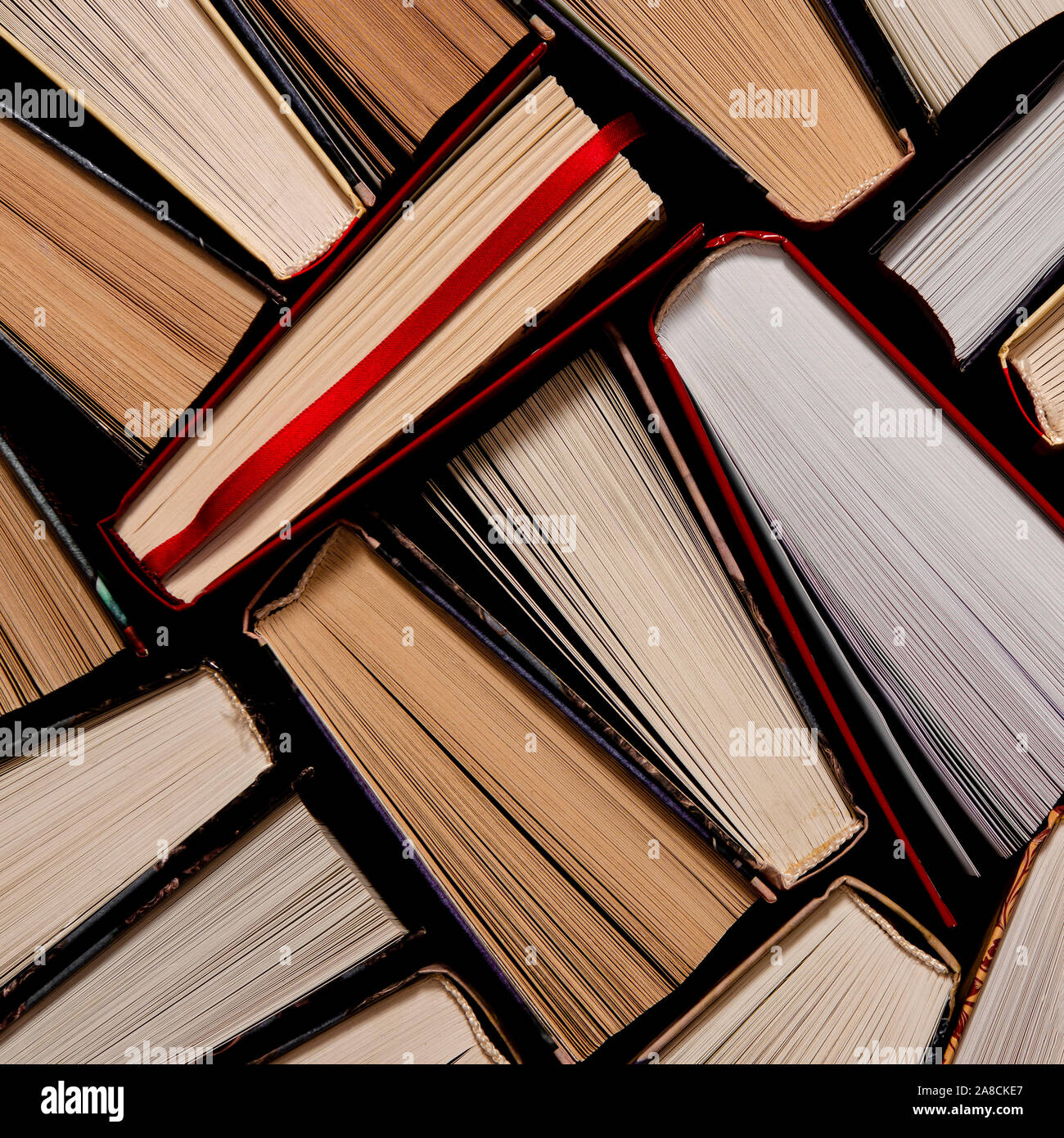 Books. Lots of colourful thick open books stand on a dark background ...
