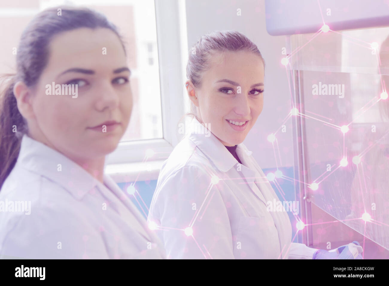 Two young female Laboratory scientists working at lab with test tubes ...