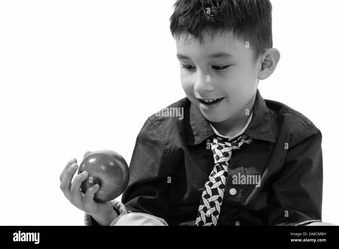 Studio shot of cute happy boy smiling and holding red apple Stock Photo ...