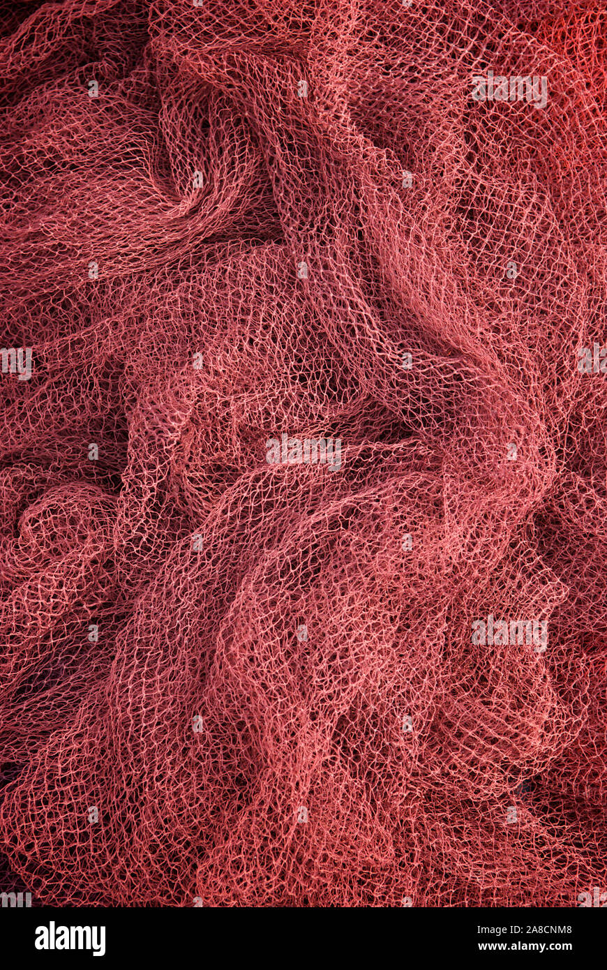 Full frame background of red plastic fishing net, which when abandoned ...