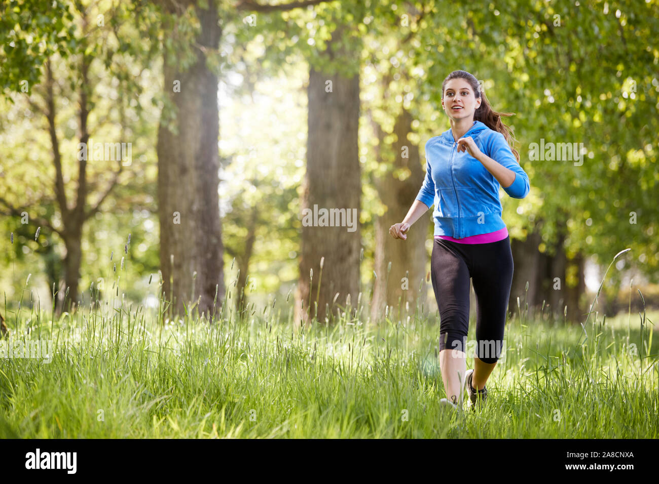 Young women running through park hi-res stock photography and images ...