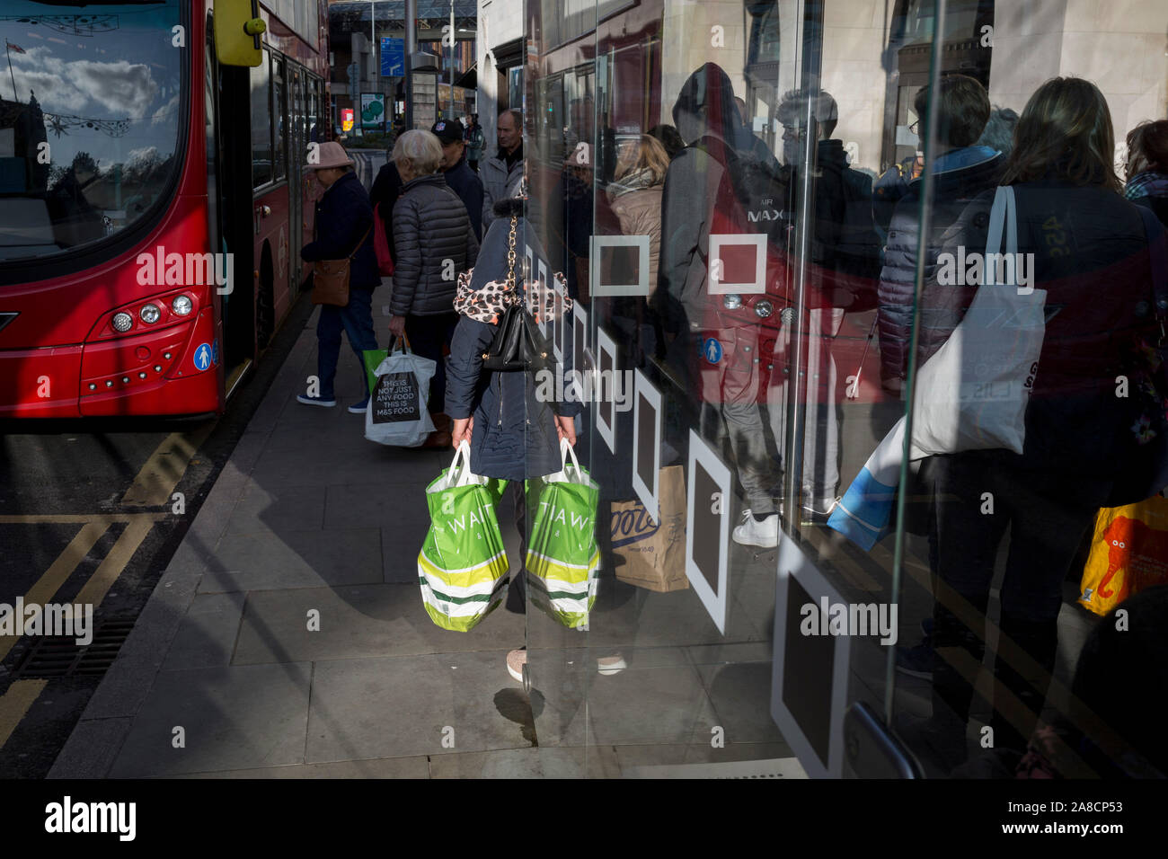 Passengers board a London bus at a bus stop in Kingston, on 7th ...