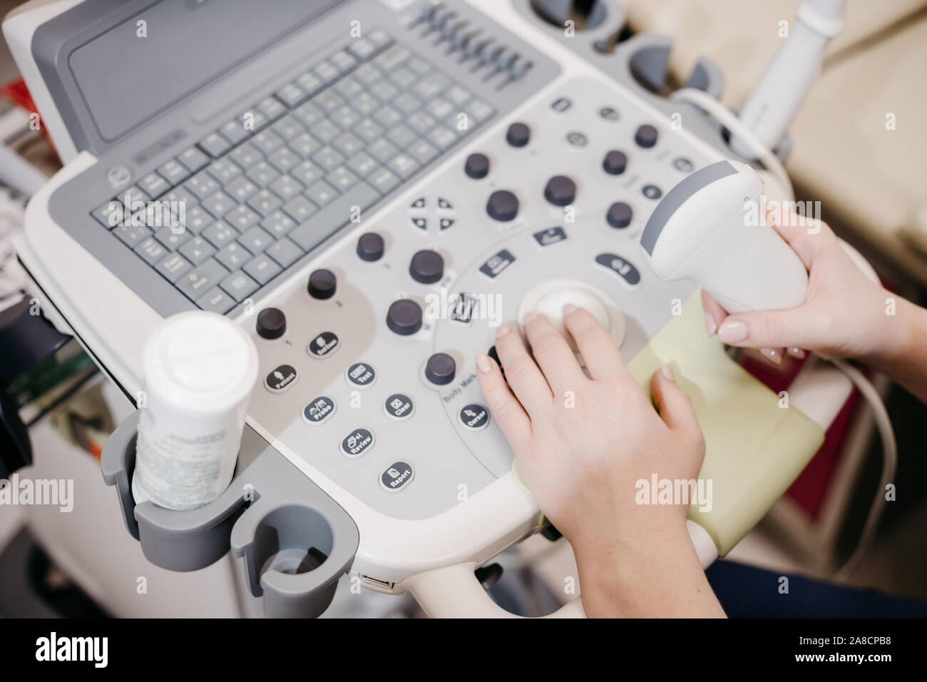 Doctors hands use an ultrasound medical device in a private clinic ...