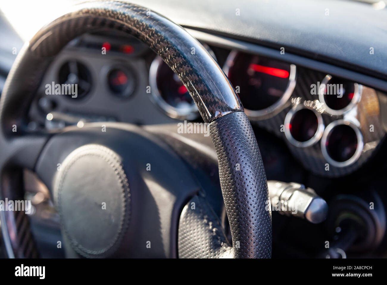 Carbon steering wheel of a black car in the workshop tightened and ...